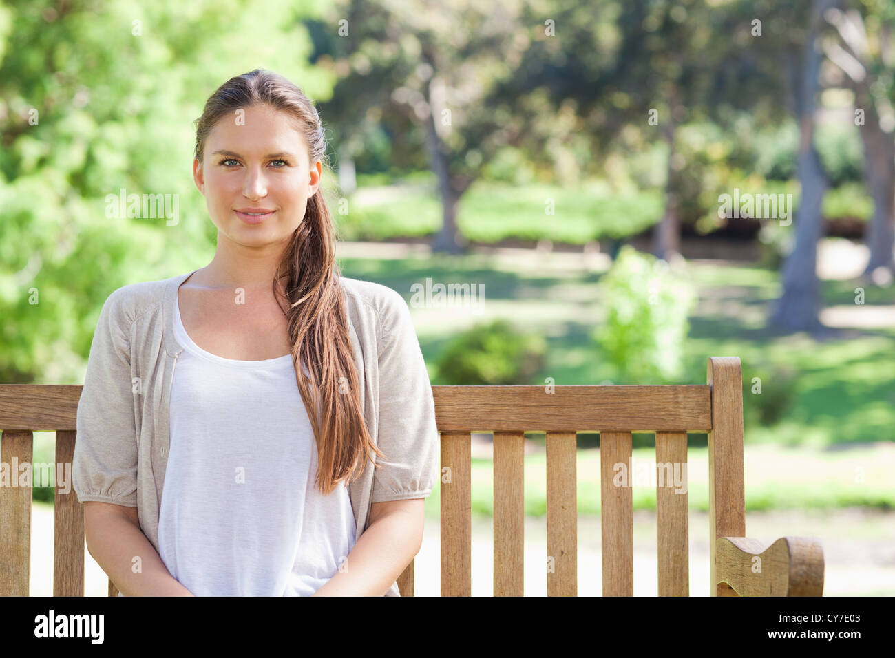 Woman sitting on a park bench Stock Photo - Alamy