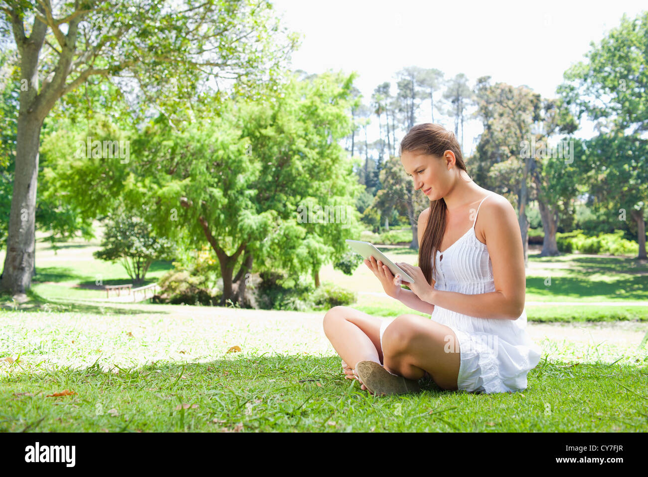 Side view of woman on the lawn with her tablet computer Stock Photo - Alamy