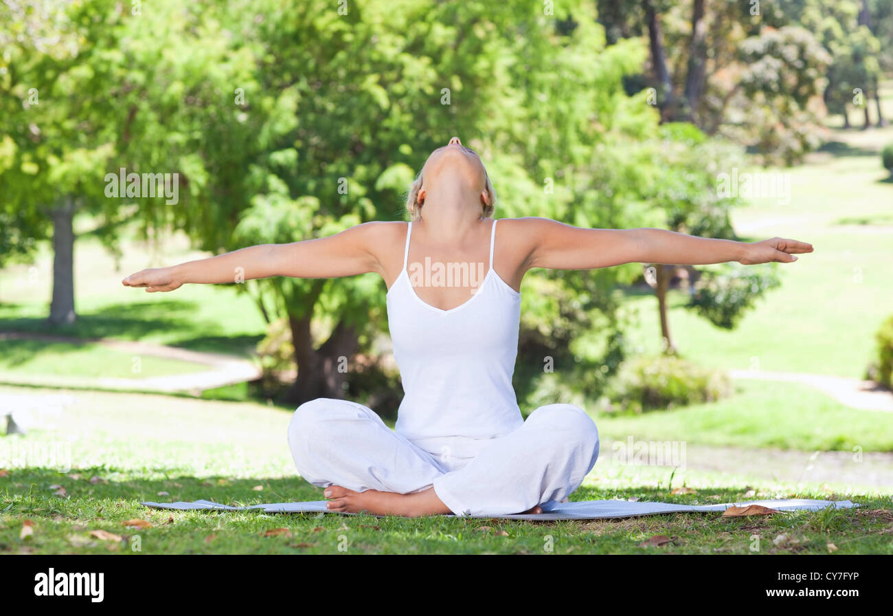 Woman on the lawn doing yoga exercises Stock Photo - Alamy
