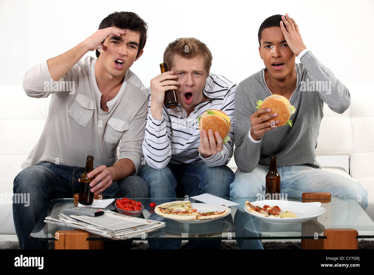 Three lads cringing at the television Stock Photo - Alamy
