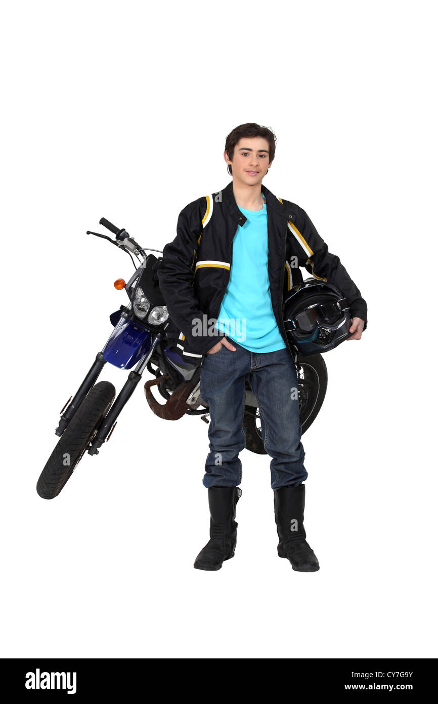 Teenager boy standing by a motorcycle Stock Photo - Alamy