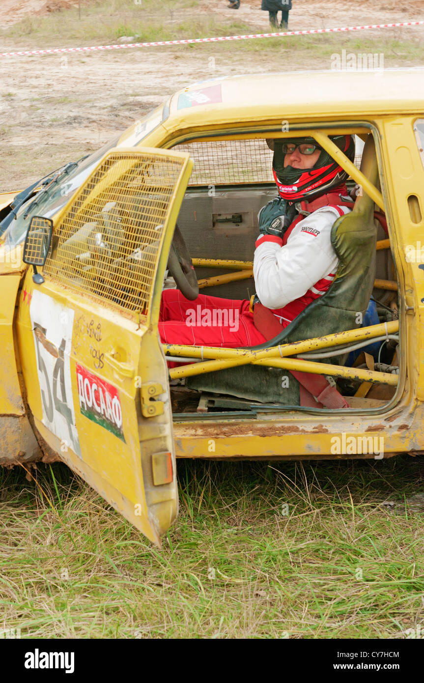 The racer clasps a helmet in the yellow racing car Stock Photo - Alamy