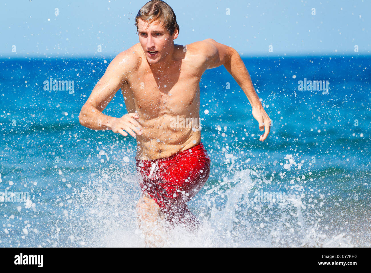 Physically fit man running on Beach Stock Photo - Alamy