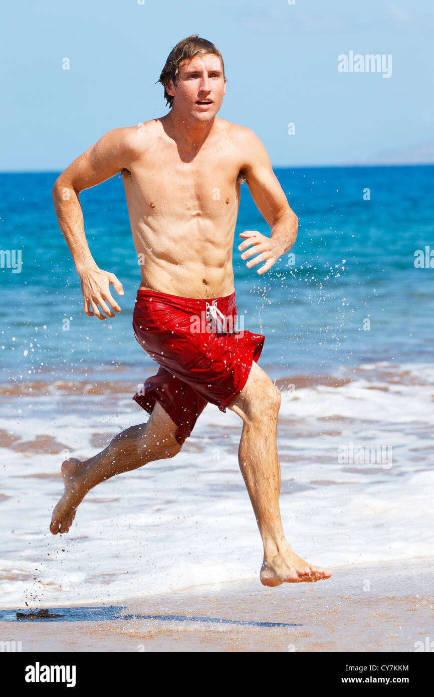 Physically fit man running on Beach Stock Photo - Alamy