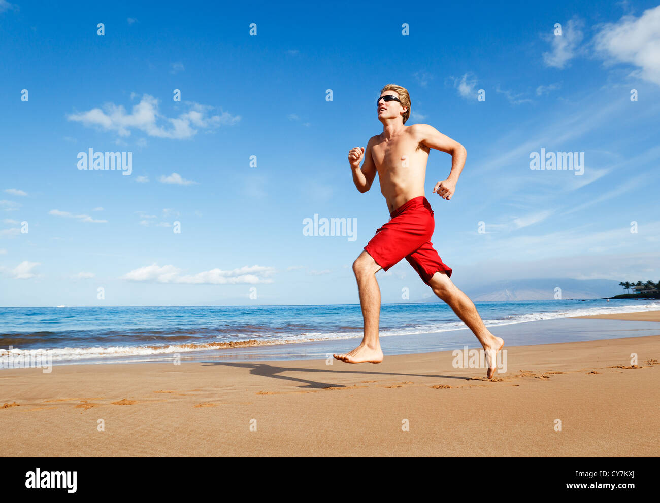 Physically fit man running on Beach Stock Photo - Alamy