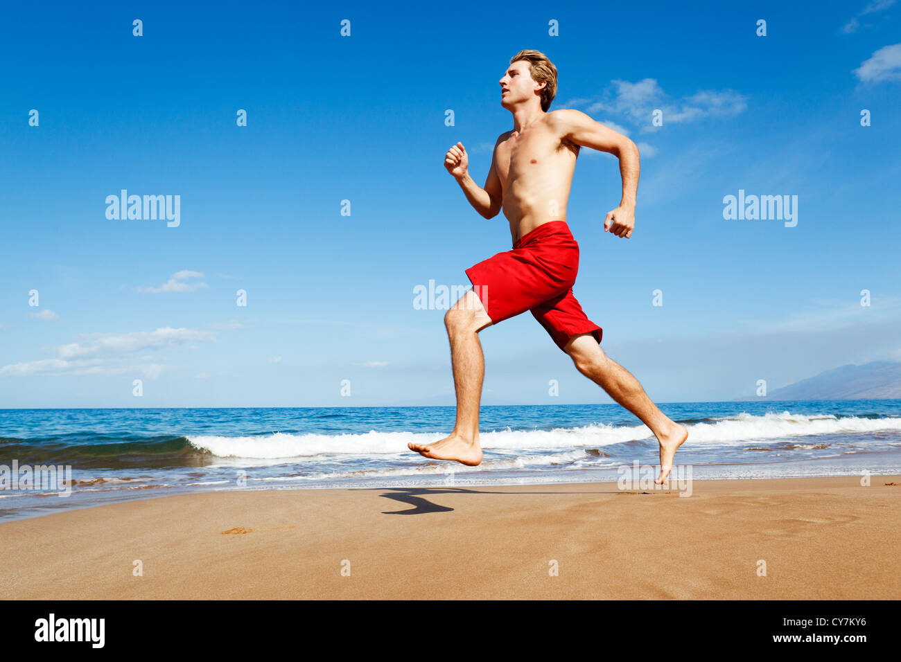 Physically fit man running on Beach Stock Photo - Alamy