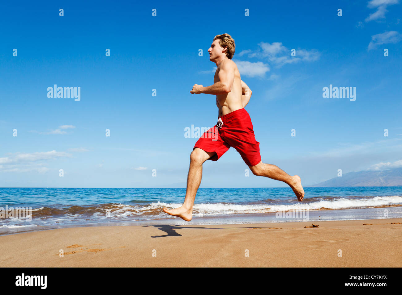 Physically fit man running on Beach Stock Photo - Alamy