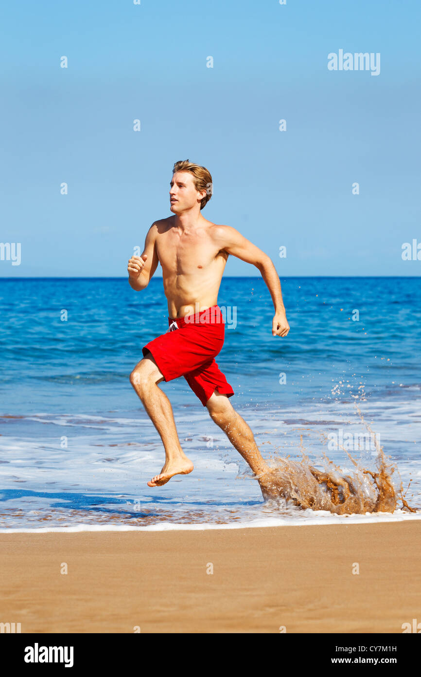 Physically fit man running on Beach Stock Photo - Alamy