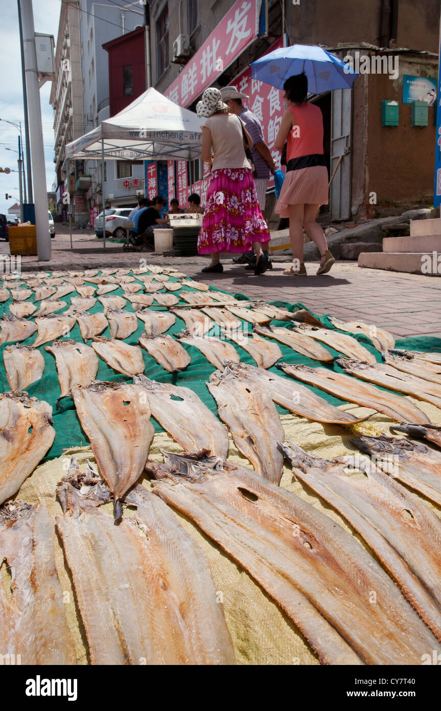 Fish drying on the pavement in the midday sun, Qingdao Old Town, China ...