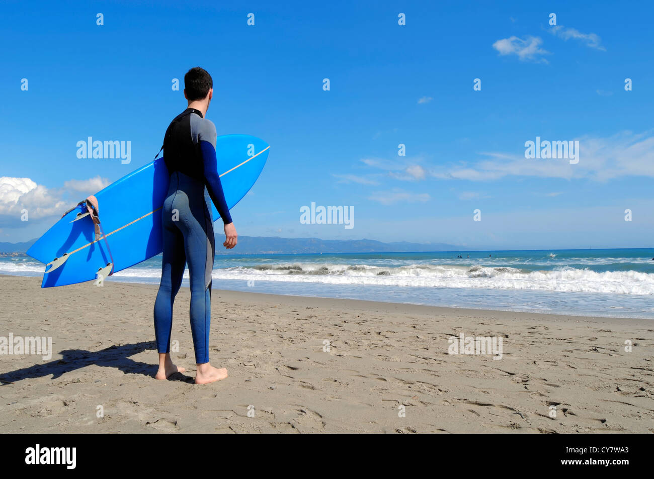 Surfer standing on the beach Stock Photo - Alamy