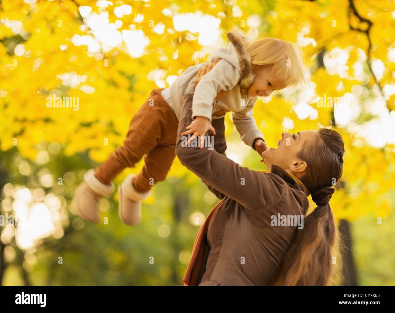 Young mother throwing baby up Stock Photo - Alamy