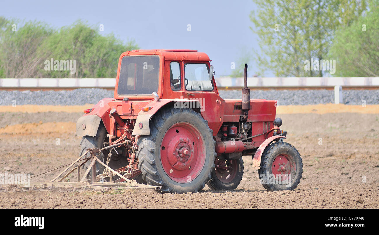 Old red russian tractor is cultivating in early spring Stock Photo - Alamy