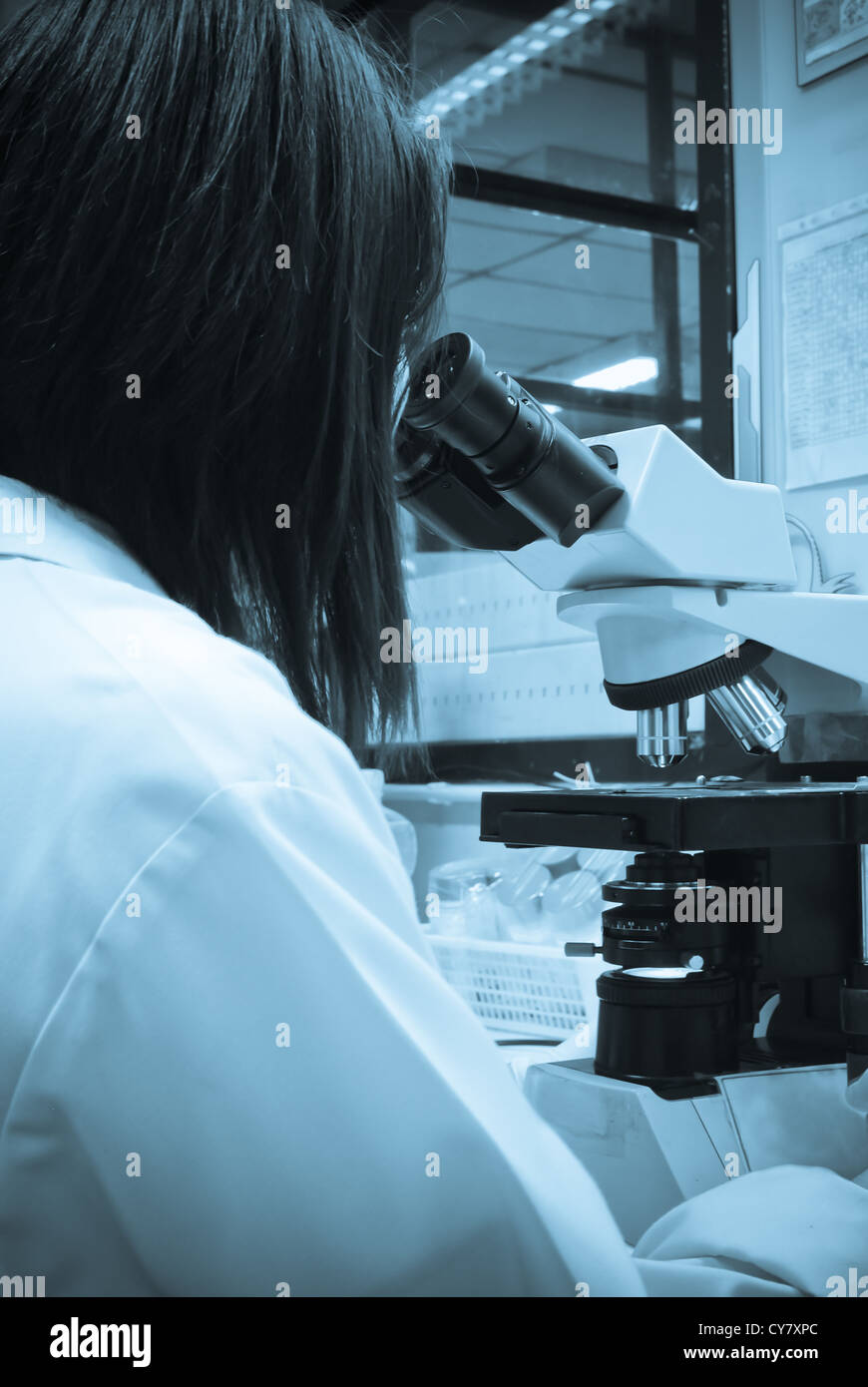 Serious clinician studying chemical element in laboratory microscope ...