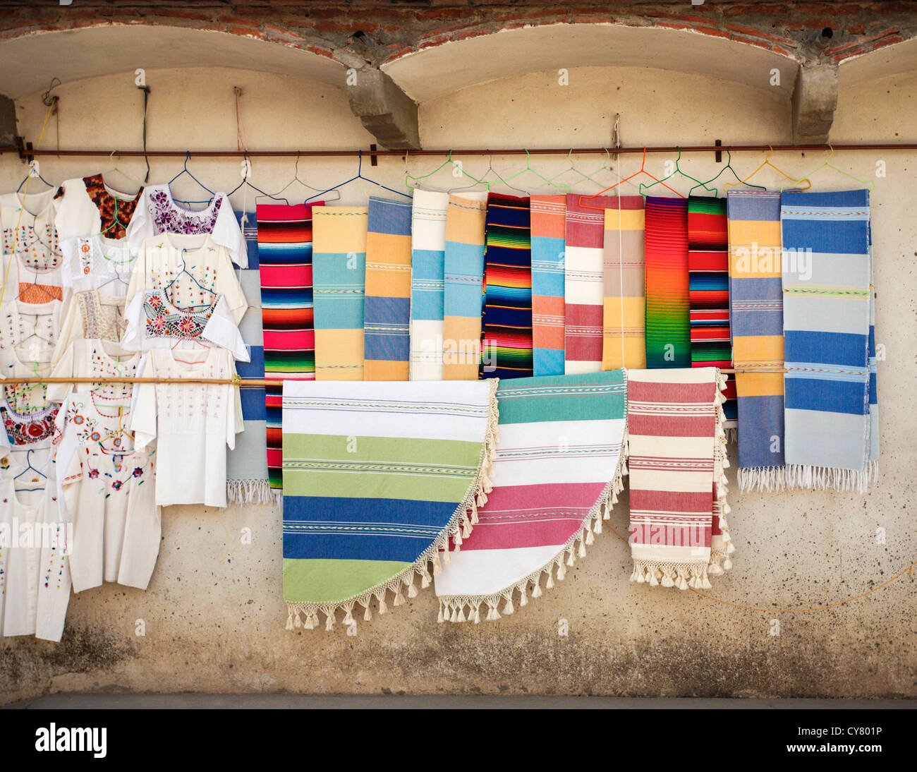 Textiles from Teotitlan del Valle line a wall in a Mitla, Oaxaca market ...