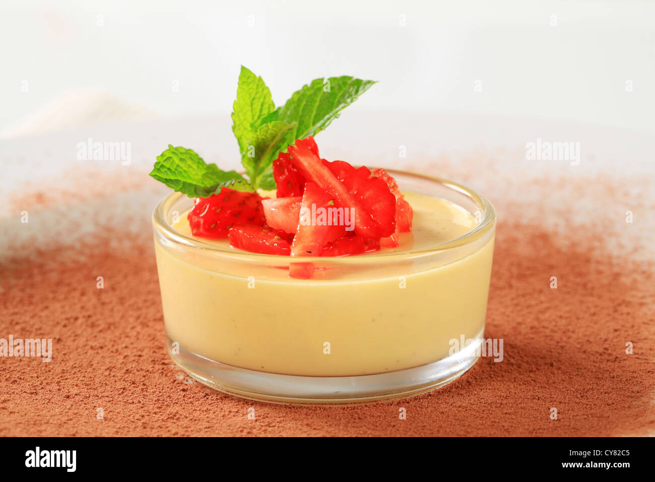 Small dish of custard topped with strawberry Stock Photo - Alamy