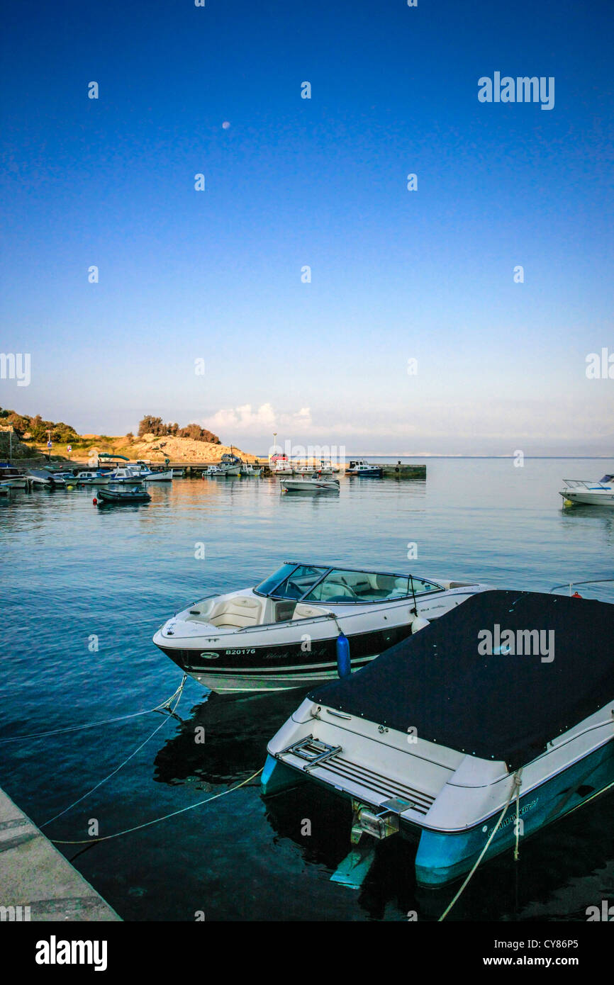 Boats on a flat calm sea in a small village harbor on the island of Krk ...