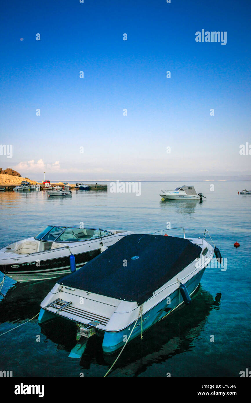 Boats on a flat calm sea in a small village harbor on the island of Krk ...