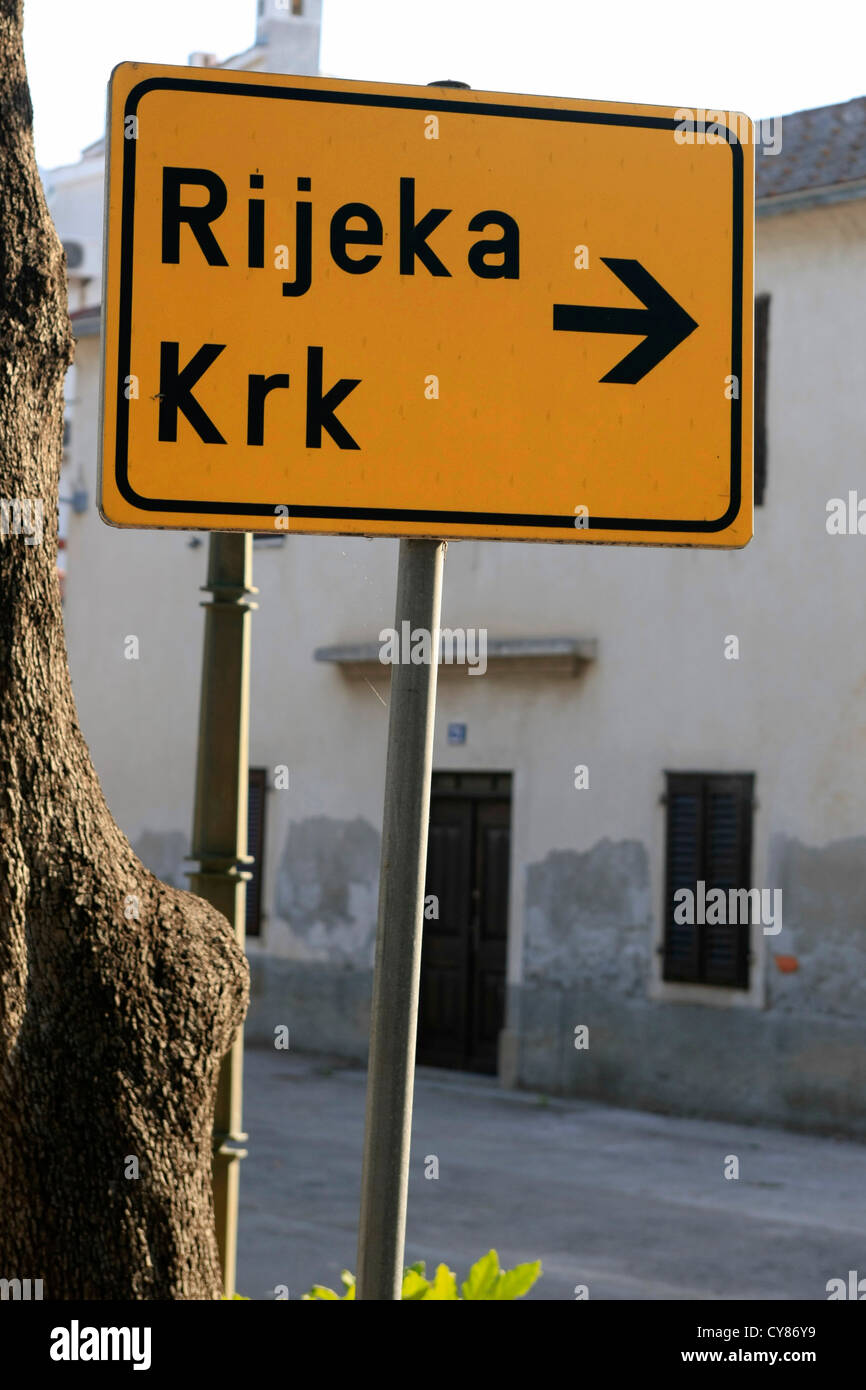 Yellow and black Croatian road sign pointing right to Rijeka and Krk ...