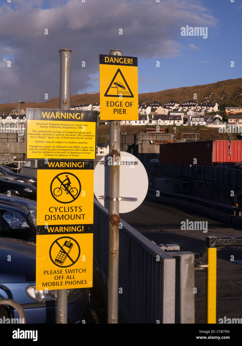 Bright yellow warning signs on the pier at Mallaig harbour in north ...