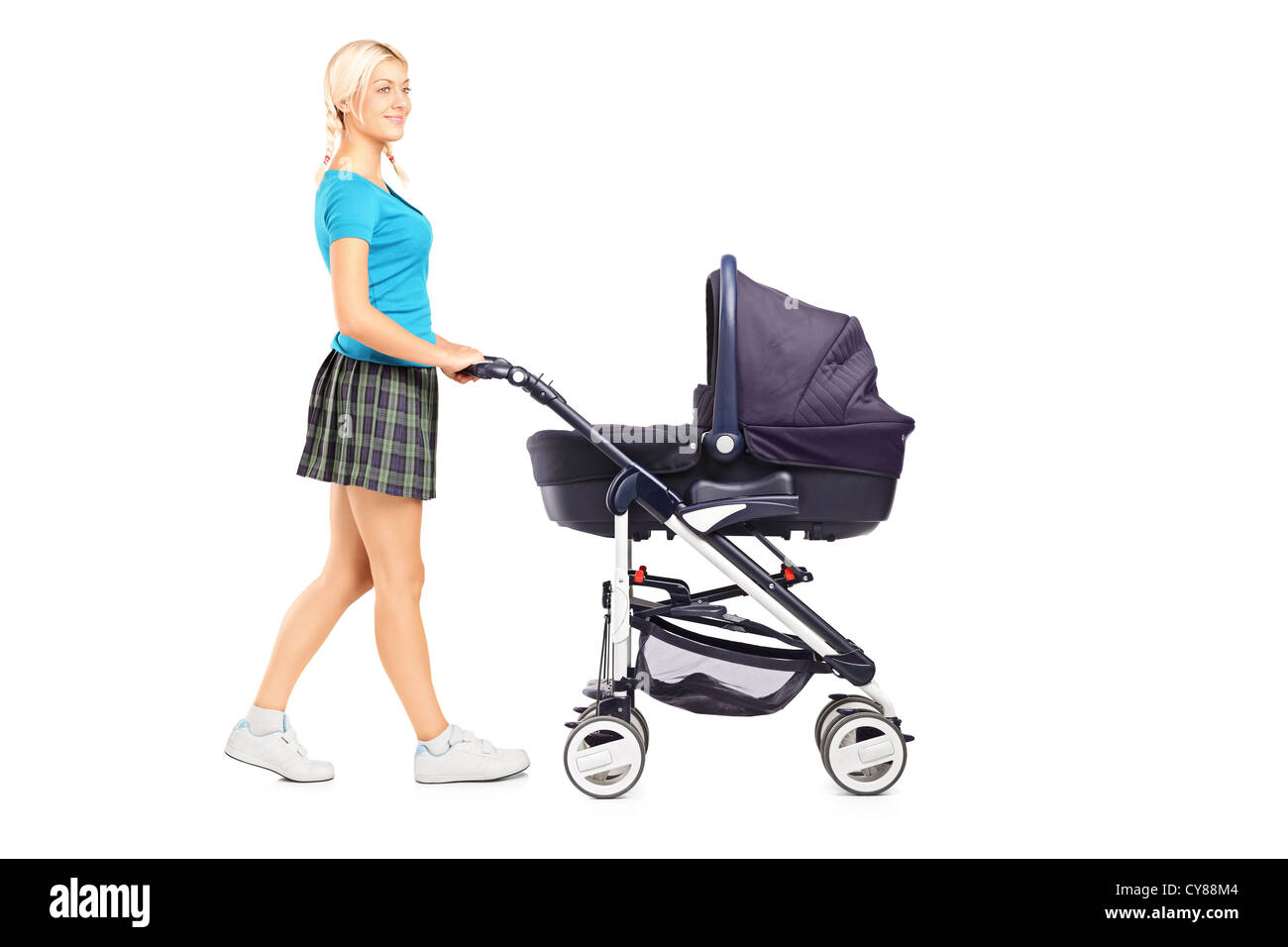 Full length portrait of a mother pushing a baby stroller isolated on ...