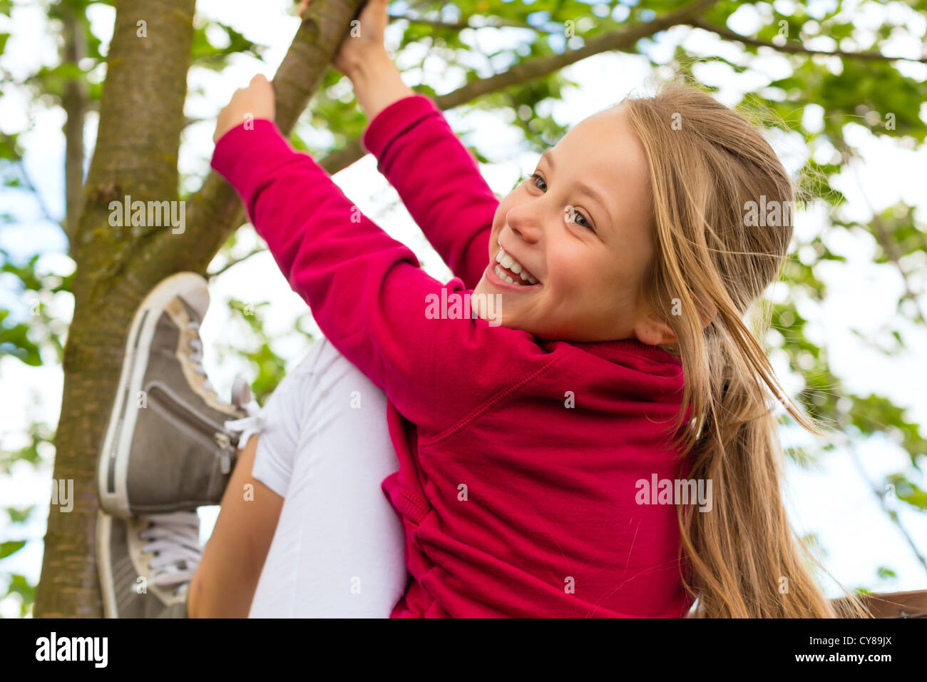 Happy child playing in the garden climbing on the tree Stock Photo - Alamy
