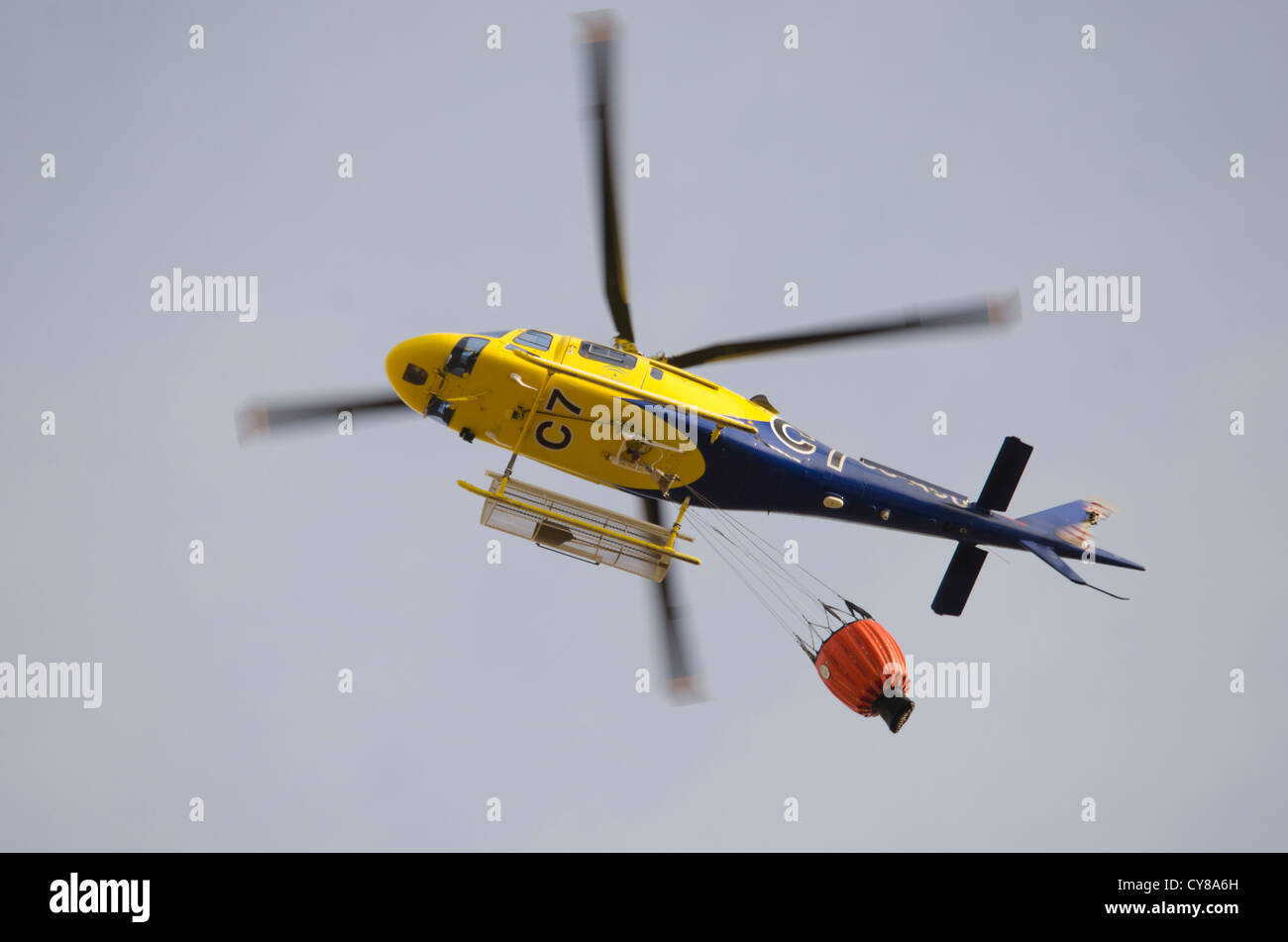 Aerial Firefighting with helicopter water bombing a bushfire near an ...