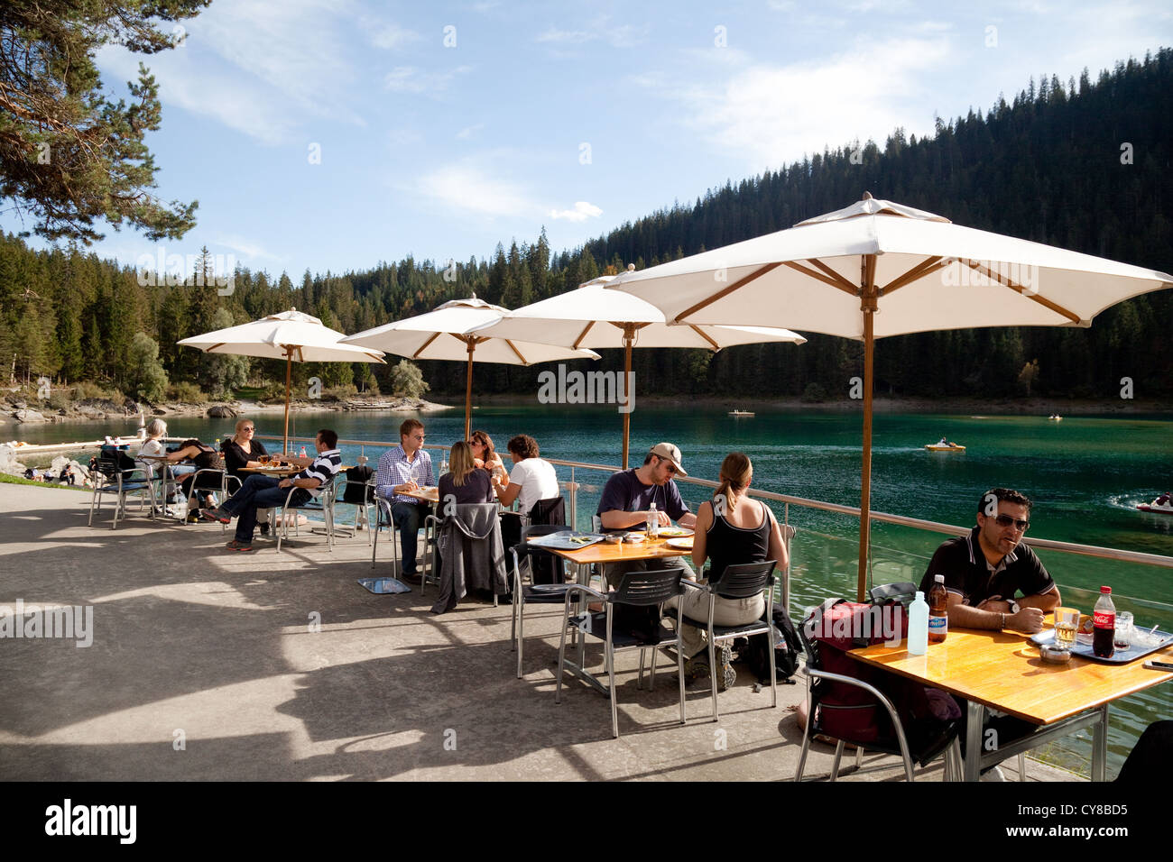 People eating and drinking at a cafe on the shore of lake cauma ...