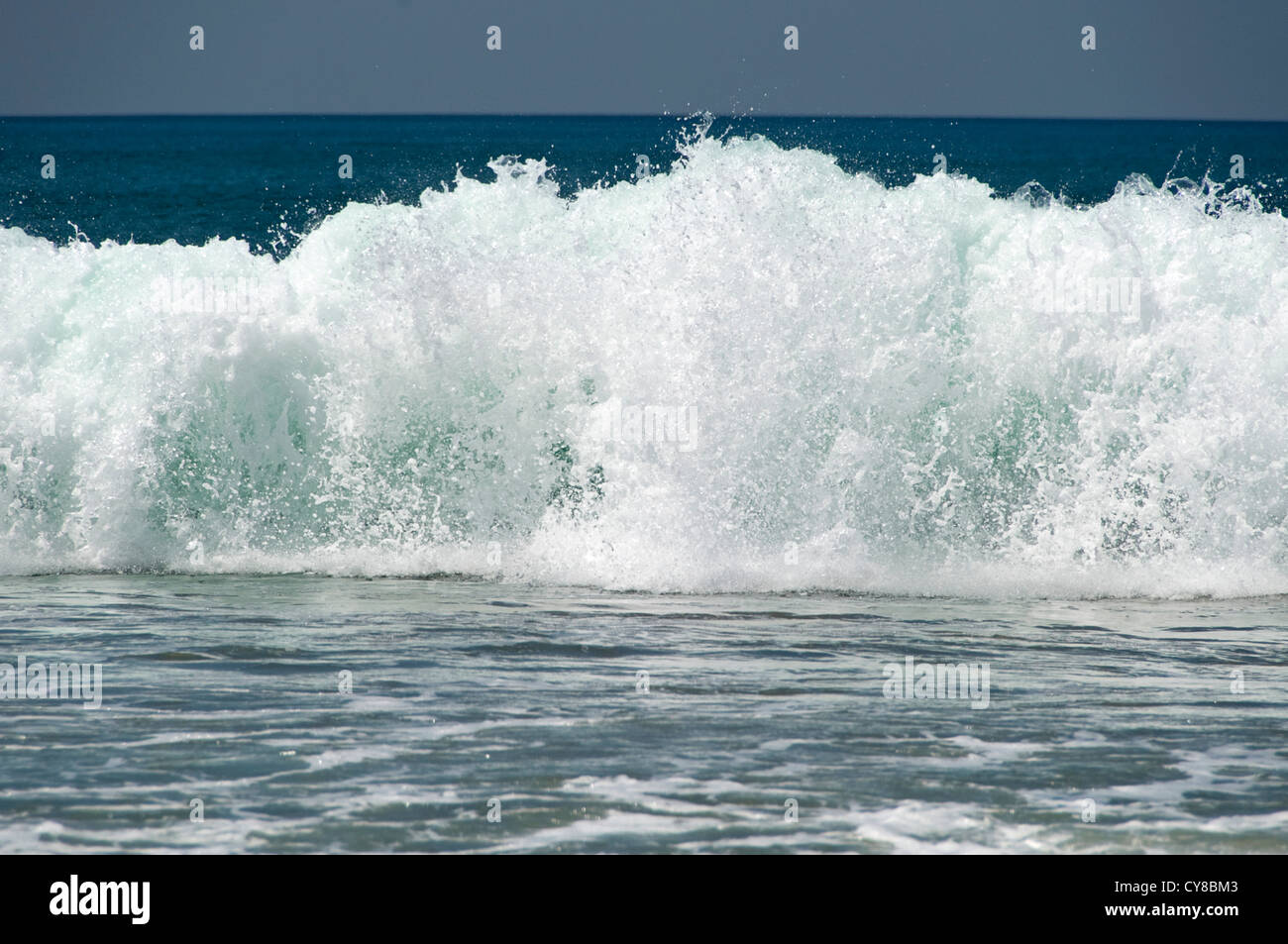 Horizontal close up of a wave crashing onto the beach in Kovalam, India ...