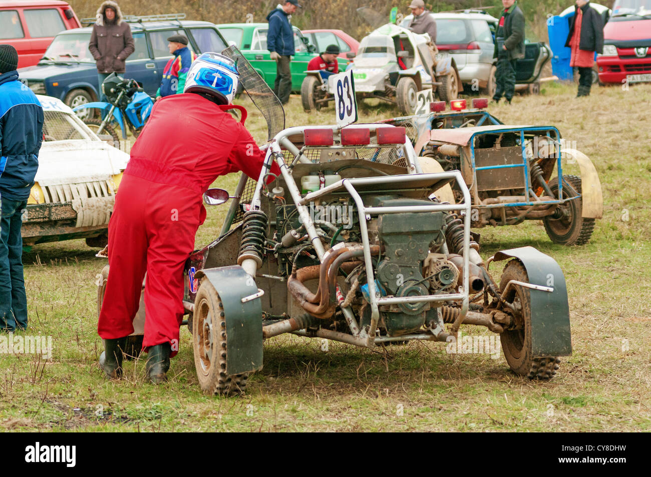 The racer in red overalls rolls racing buggy-cart Stock Photo - Alamy