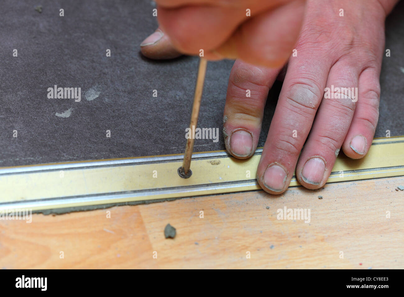 Man Construction worker is tiling at home, tile floor adhesive ...