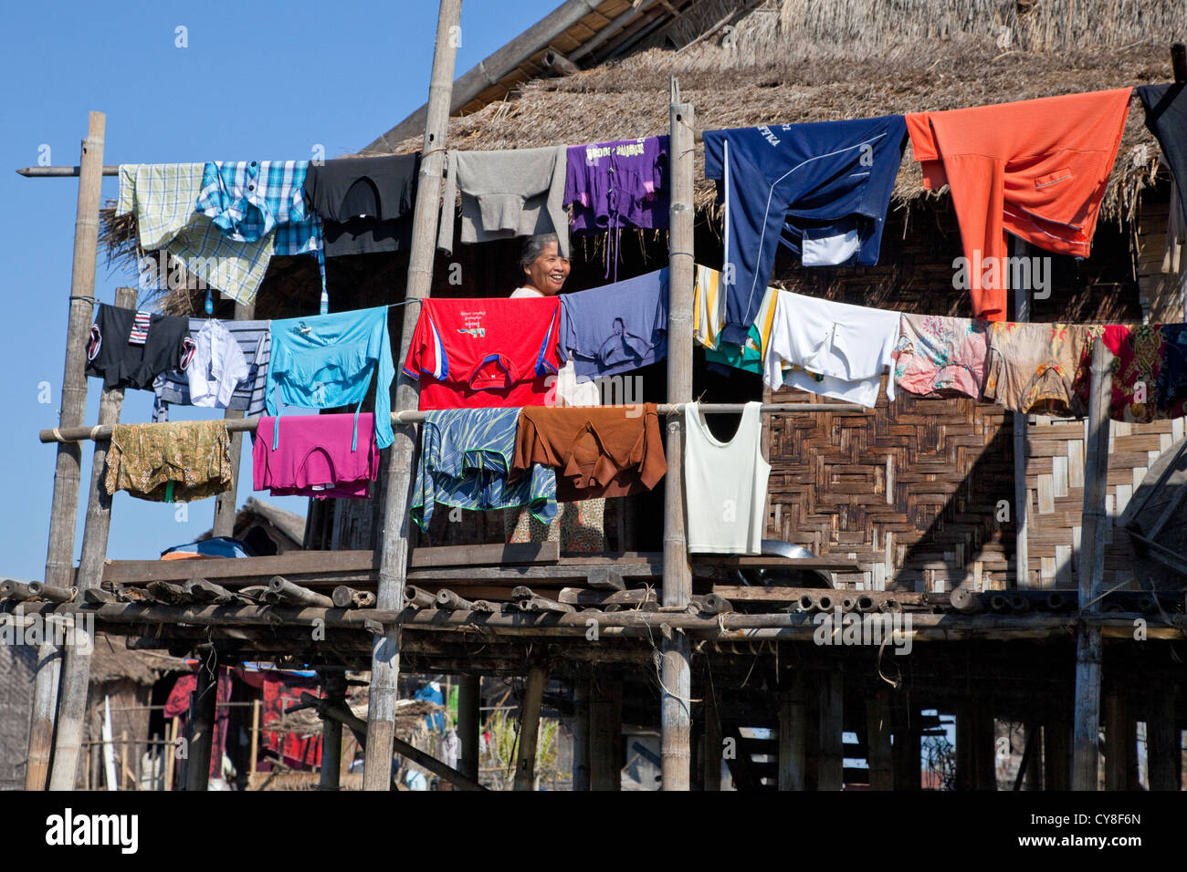 Myanmar, Burma. Burmese Woman Hanging Laundry on Balcony of House Built ...