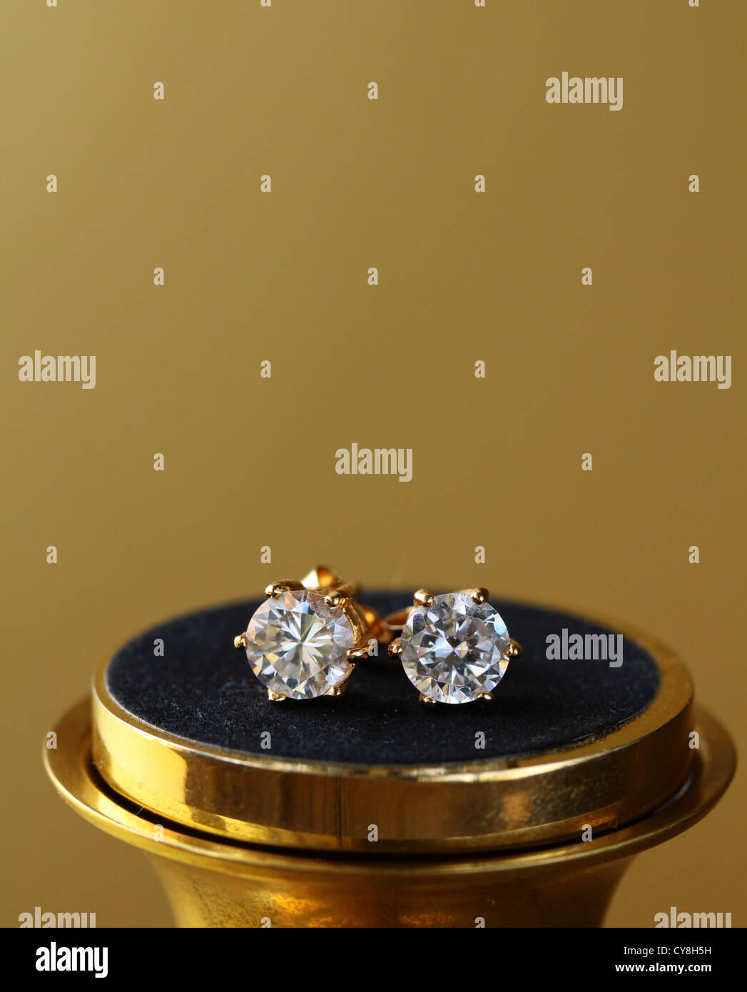 gold earrings stud with diamonds on gold background Stock Photo - Alamy