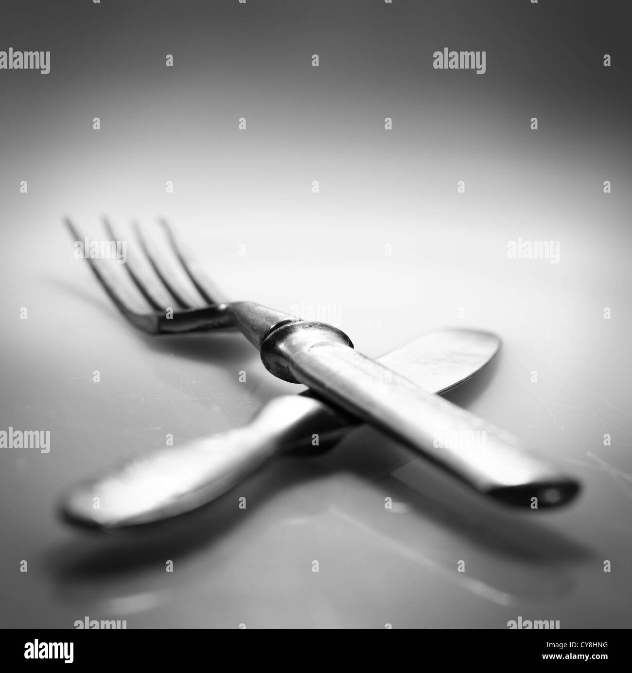 Two. Knife and fork over glass with reflection and shadow Stock Photo ...