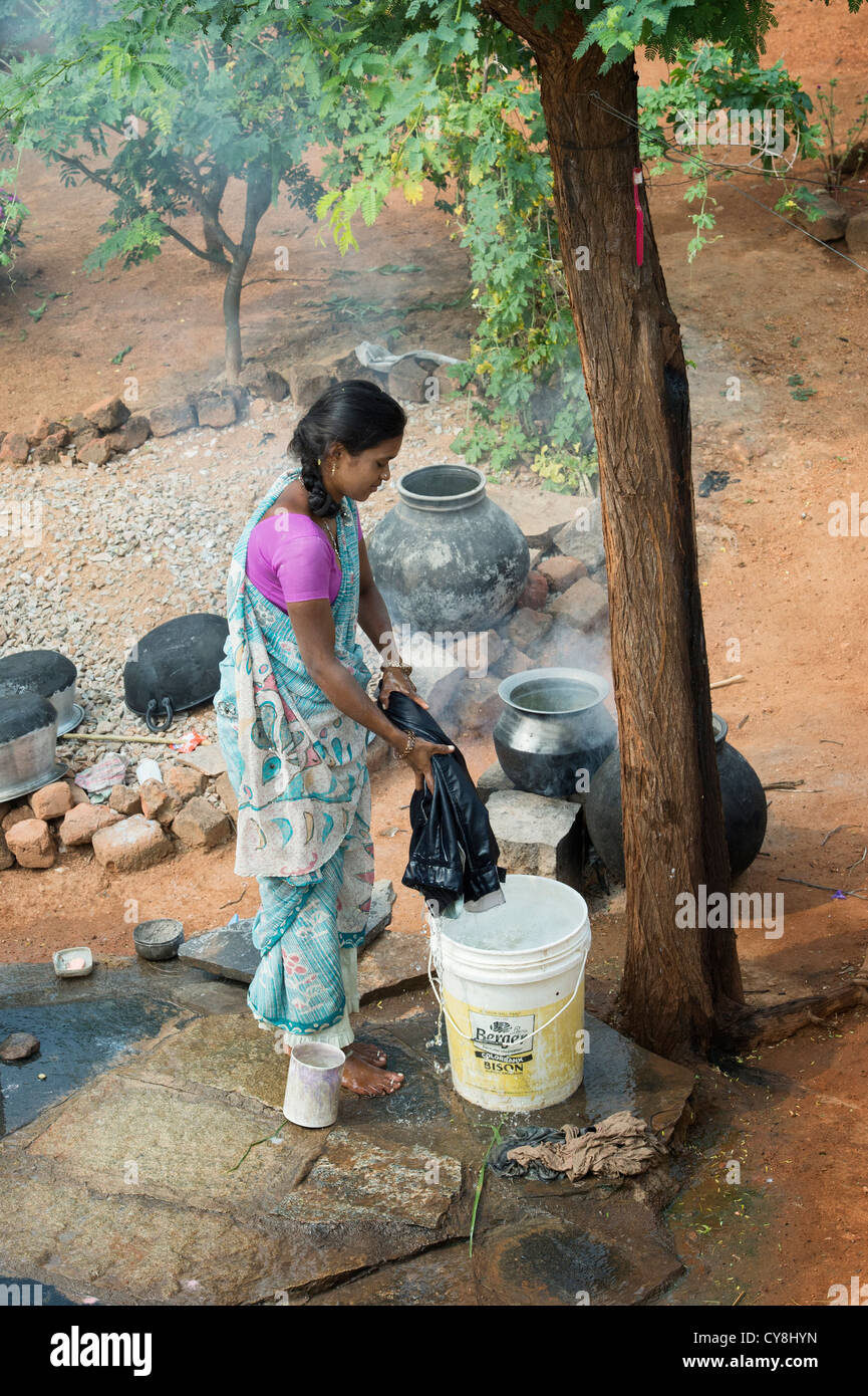 Young Indian Woman Washing Clothes Outside Her Home In A Rural Indian