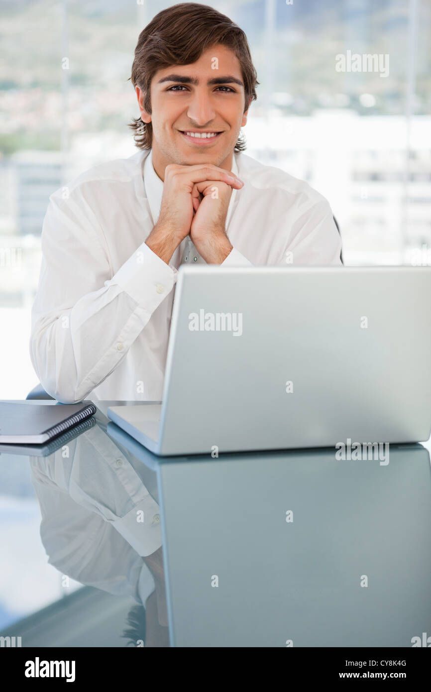 Smiling young businessman resting his head on his hands Stock Photo - Alamy