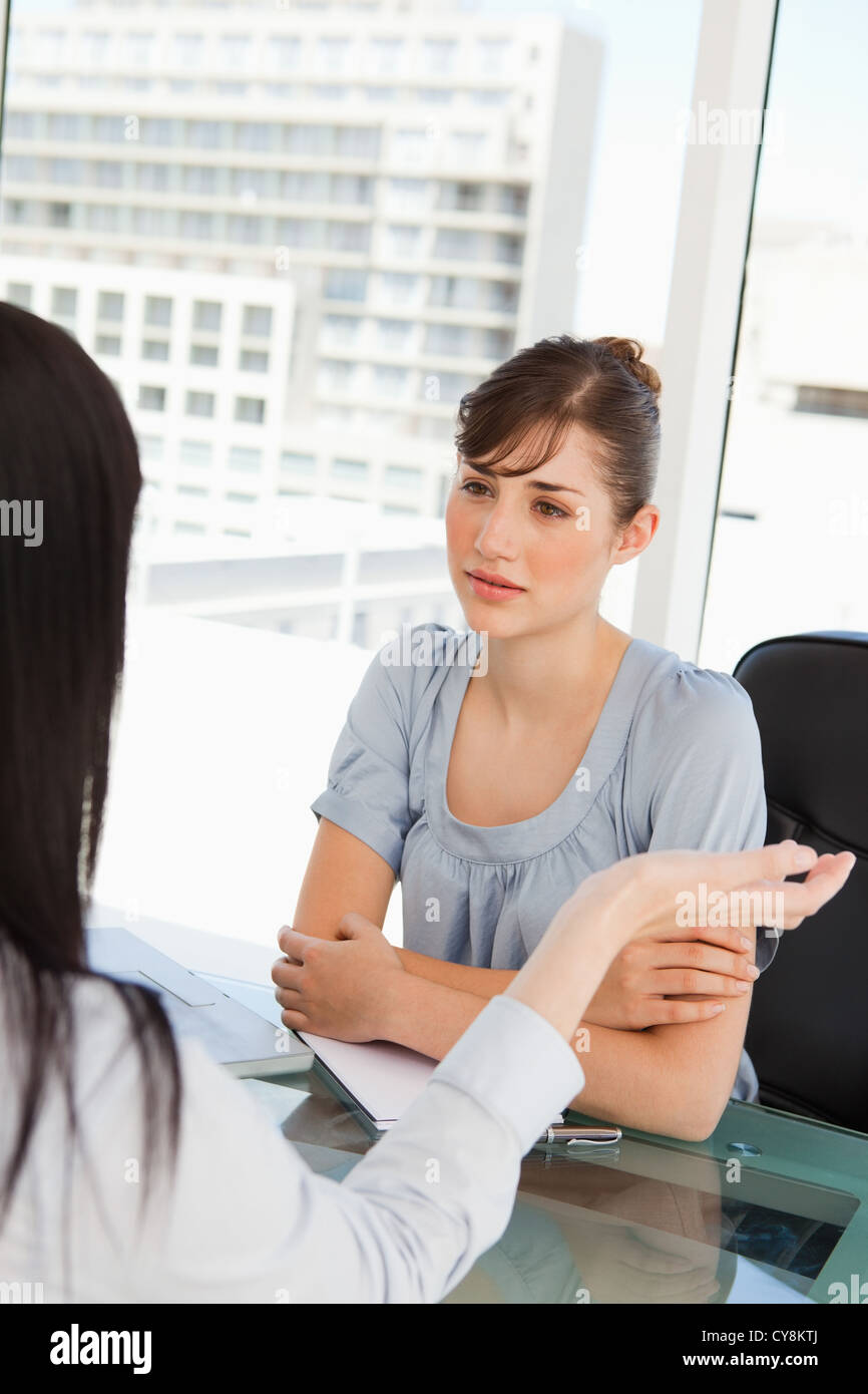 Brunette worker listens to her co-worker Stock Photo - Alamy