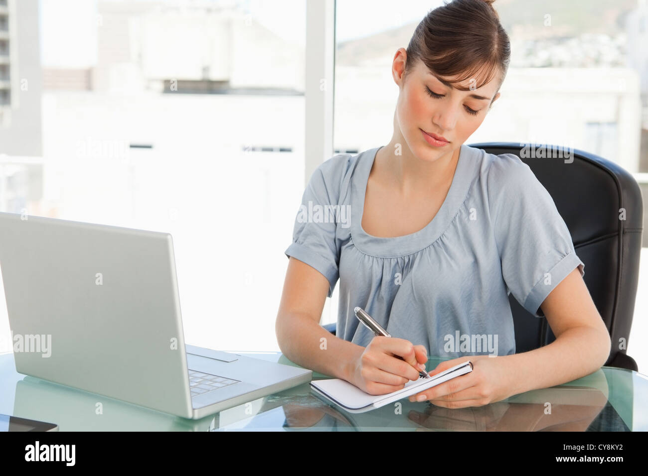 Woman takes down notes on her notepad Stock Photo - Alamy