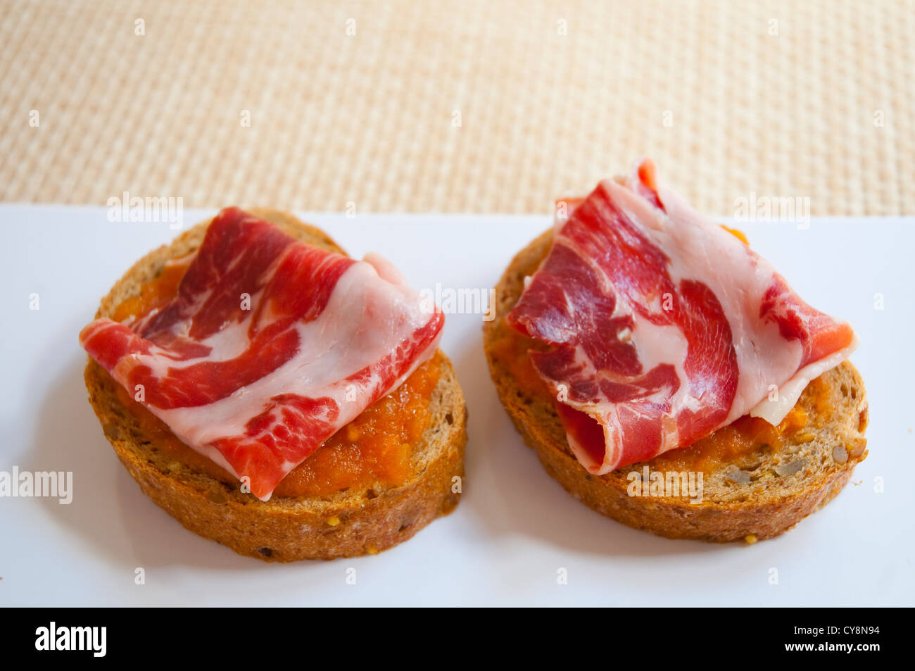 Spanish tapa: Iberian ham with tomato sauce. Close view Stock Photo - Alamy