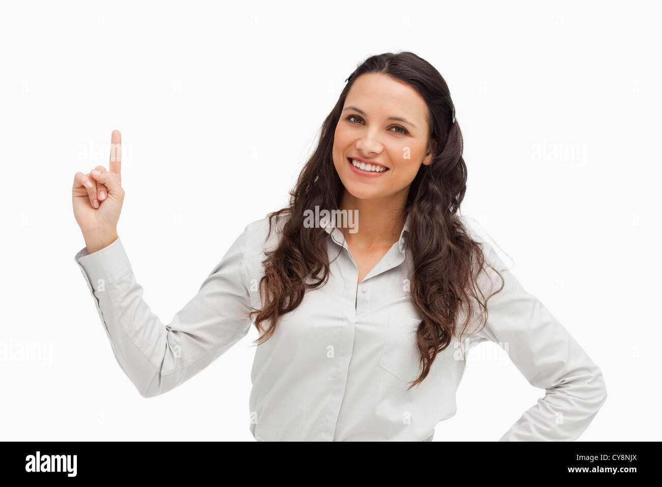 Portrait of a brunette woman pointing up Stock Photo - Alamy