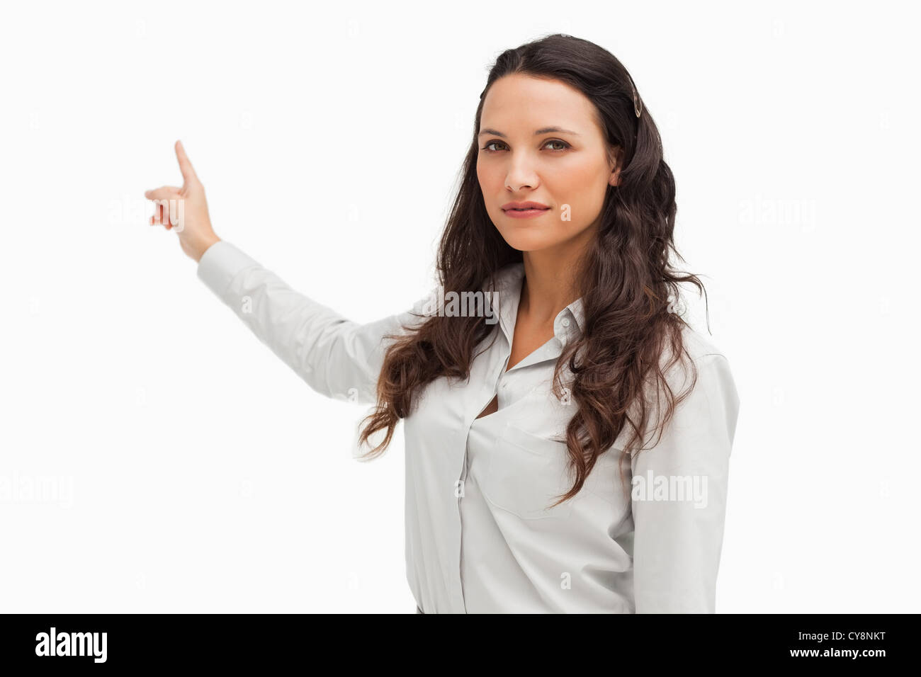 Portrait of a brunette woman pointing behind her Stock Photo - Alamy