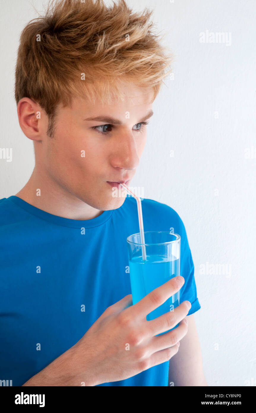 Young man drinking blue soft drink Stock Photo - Alamy