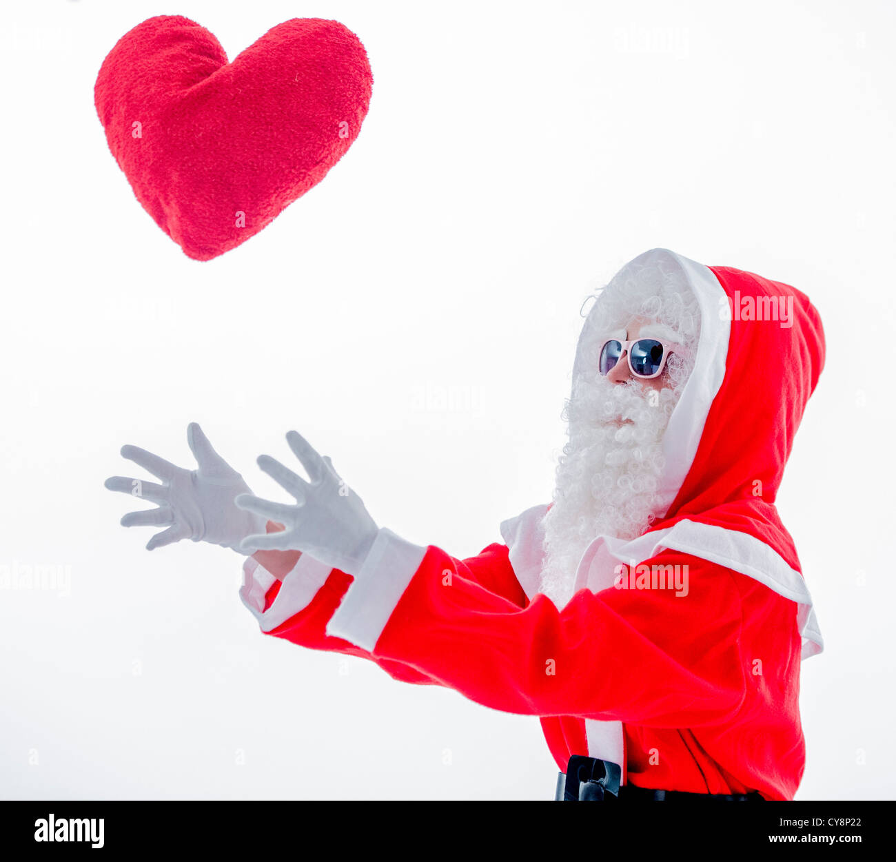 Santa Claus catching a red heart isolated on white background Stock ...
