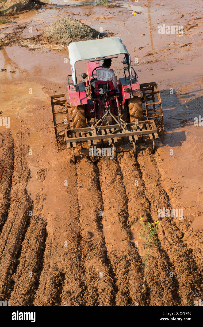 Ploughing tractor preparing a rice paddy field in the indian ...