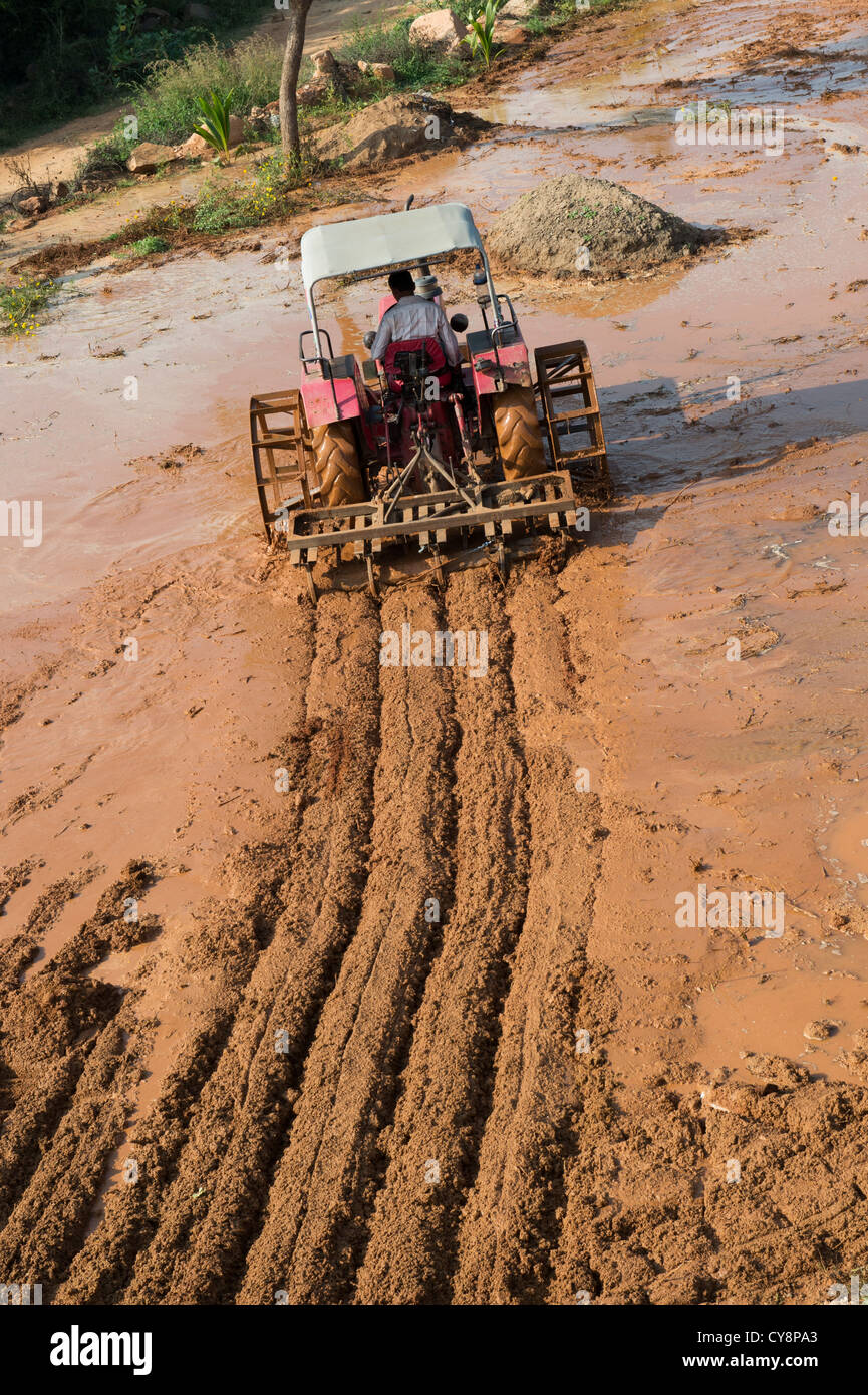 Ploughing tractor preparing a rice paddy field in the indian ...