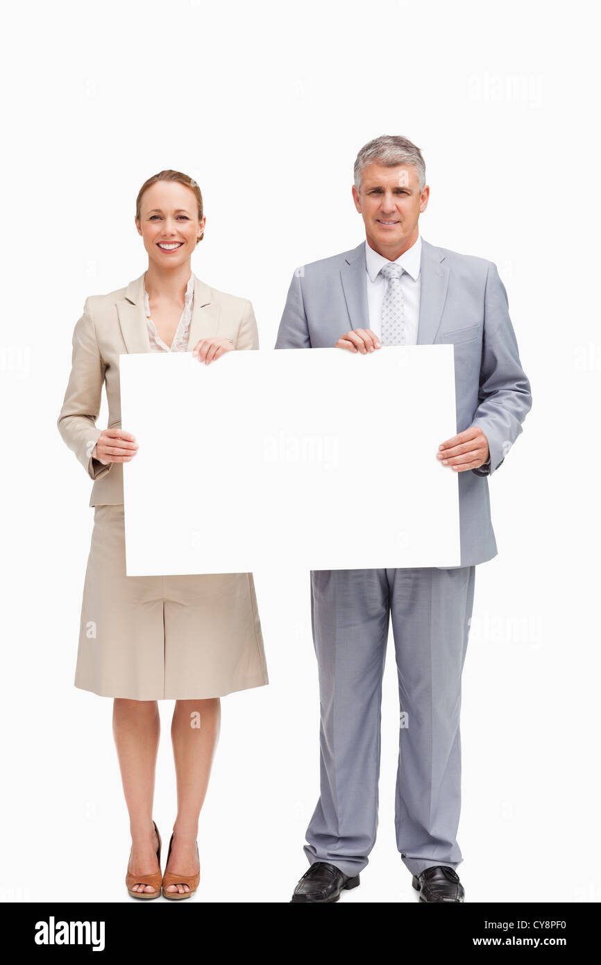 Business people smiling while holding a poster Stock Photo - Alamy