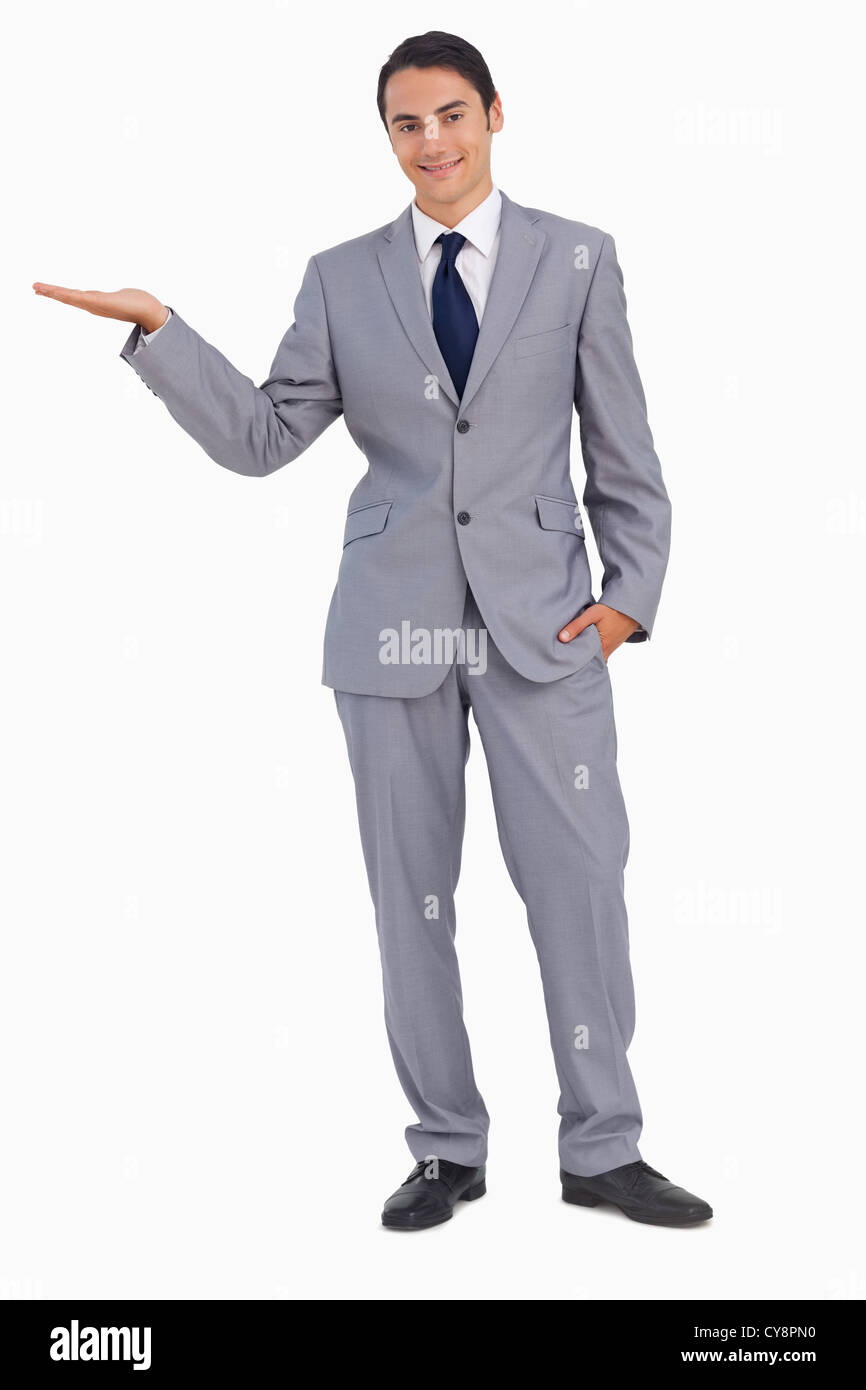 Smiling man in suit presenting with the hand Stock Photo - Alamy