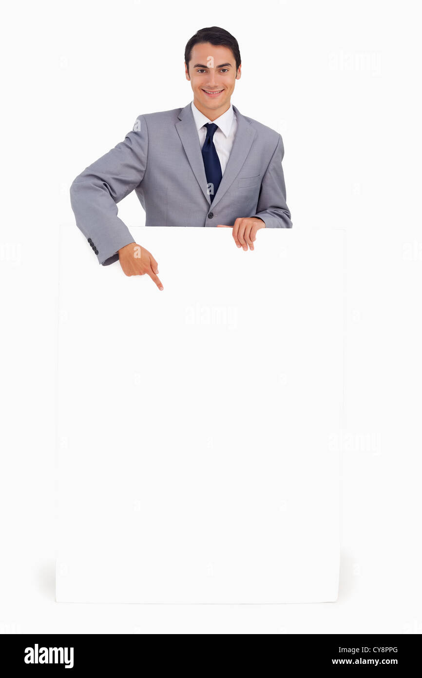 Good-looking man holding and pointing at a big poster Stock Photo - Alamy