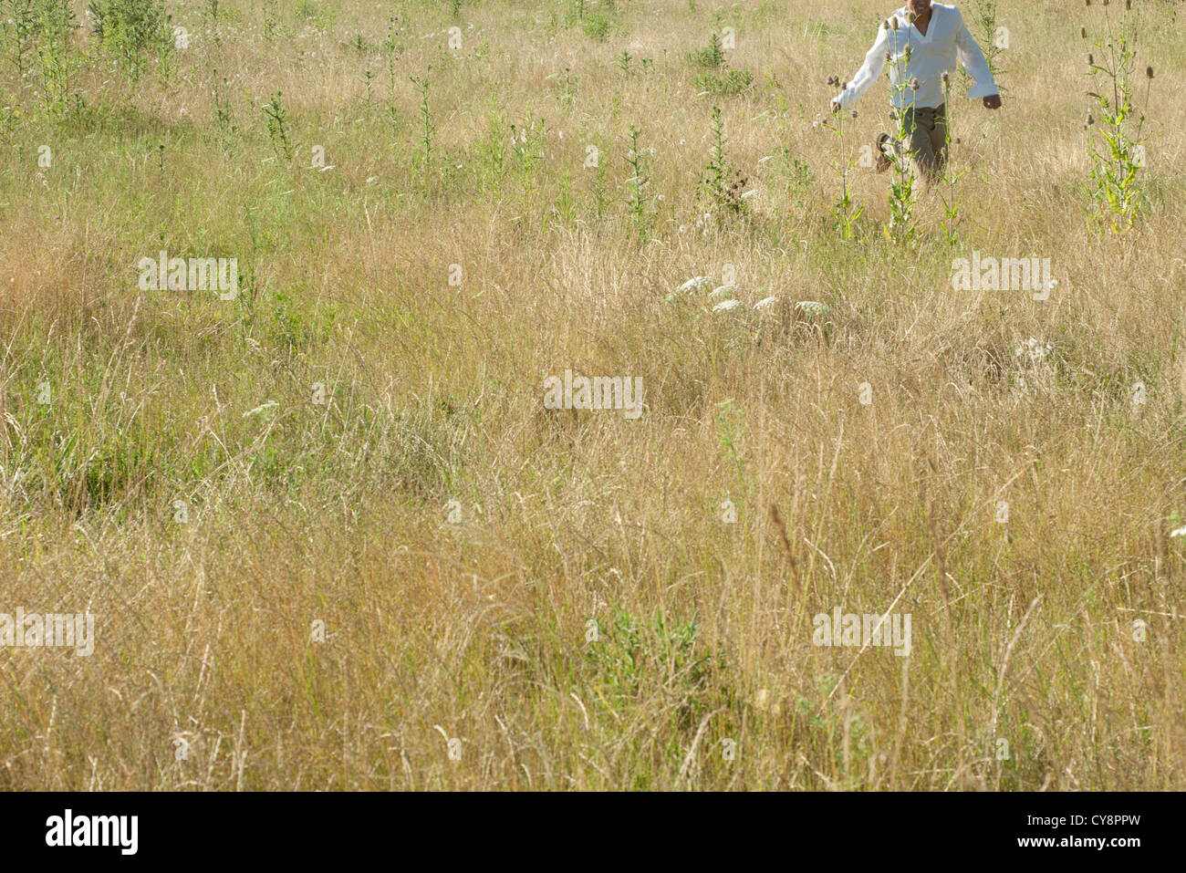 Man running through tall grass hi-res stock photography and images - Alamy