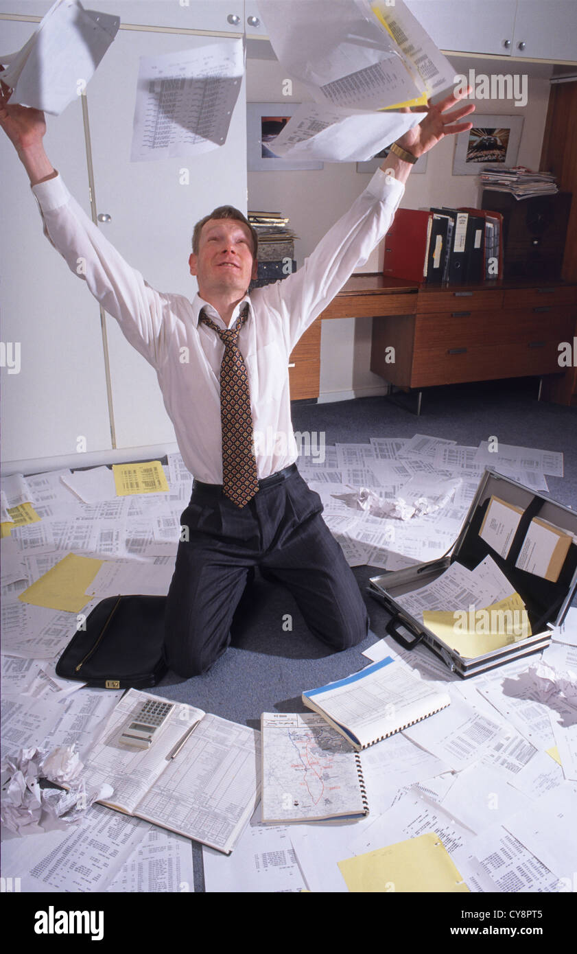 stressed businessman throwing paperwork into air in office Stock Photo ...