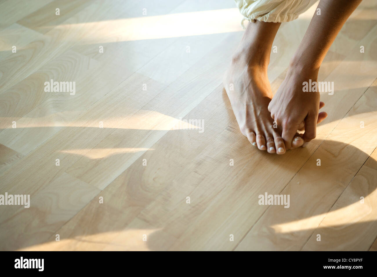 Woman bending forward touching big toe, low section, cropped Stock ...